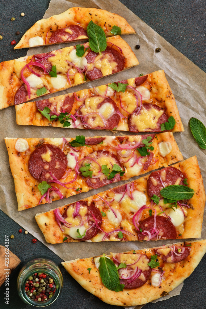 Paperoni Pizza with cheese, tomatoes and onion on a dark, concrete ...