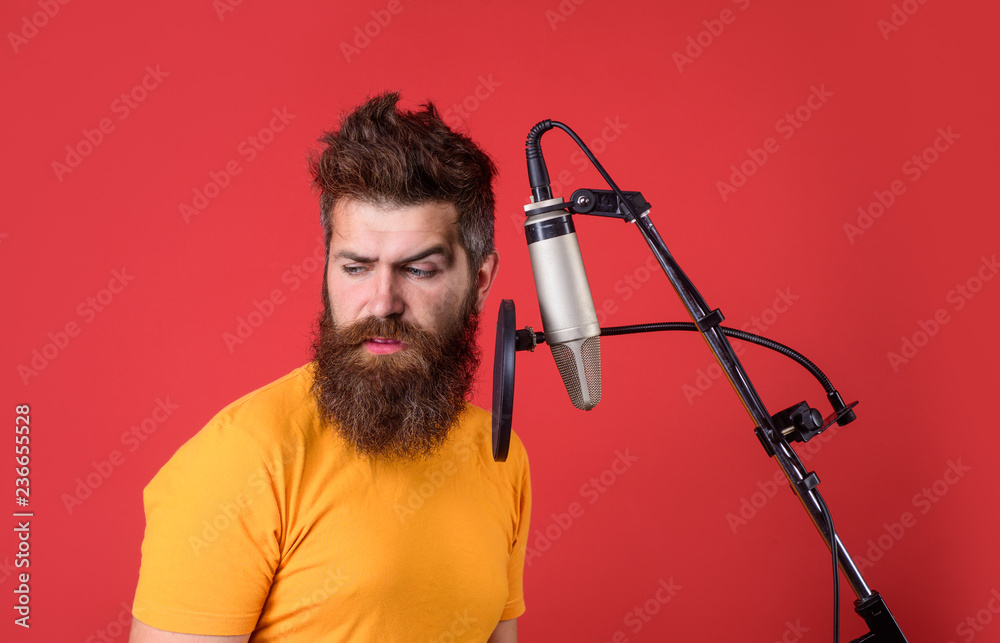 Brutal bearded guy singer with microphone on stage. Male lead vocalist ...