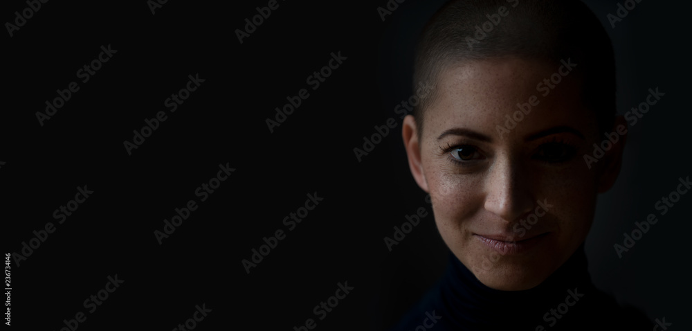 Portrait of a beautiful young courageous smiling female cancer patient ...