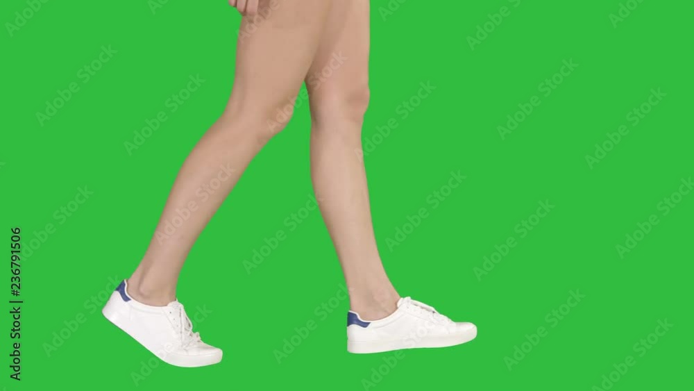 Women feet wearing white sneaker shoes walking on a Green Screen ...