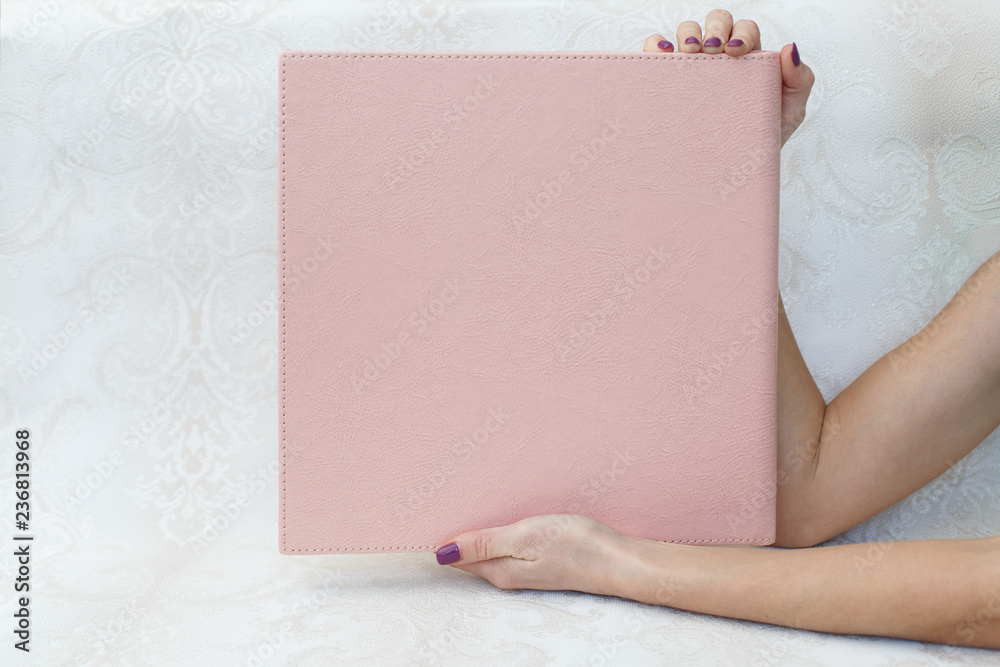 man hold a photo album photobook in the hands a woman holds a photobook ...