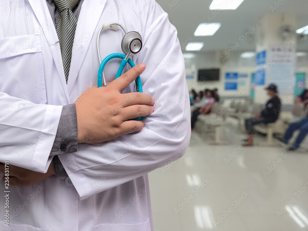 Doctor in gown uniform with stethoscope standing and fold his arms over ...