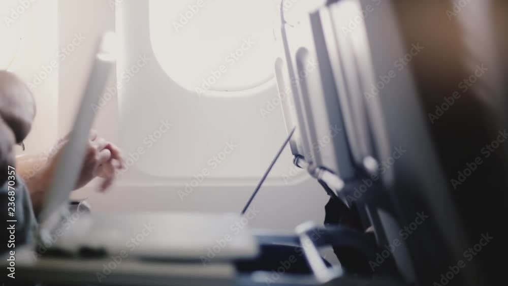 Vidéo Stock Close-up side view of plane passengers using various mobile ...
