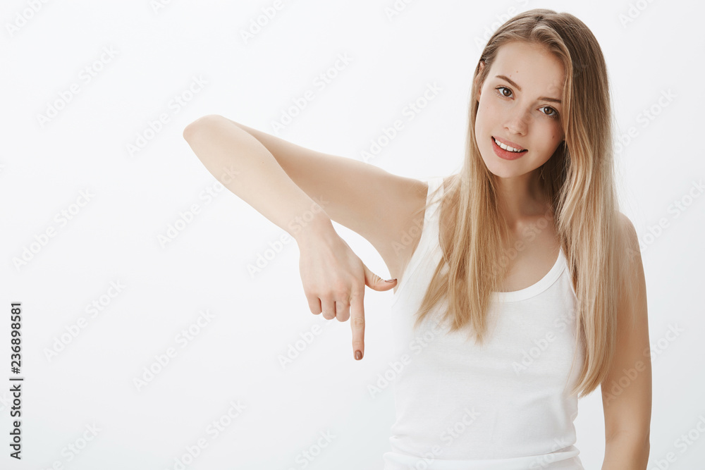 Girl pressing button as pointing down with index finger smiling ...