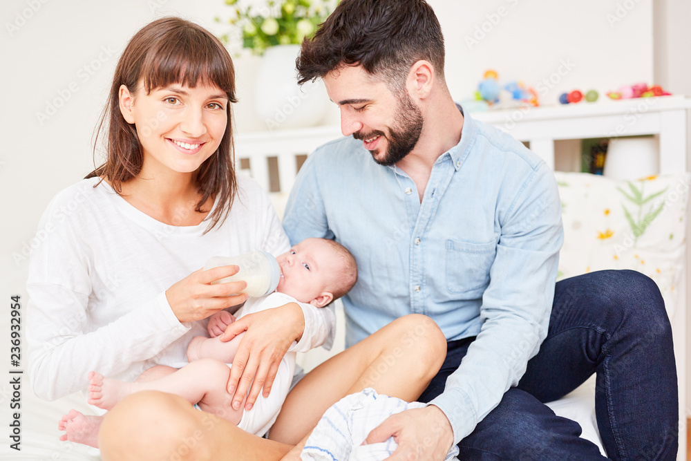 Glückliche Eltern geben Baby Flasche mit Milch Stock Photo | Adobe Stock