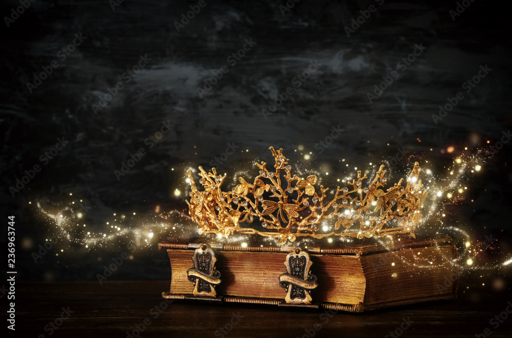 low key image of beautiful queen/king crown on old book. vintage ...