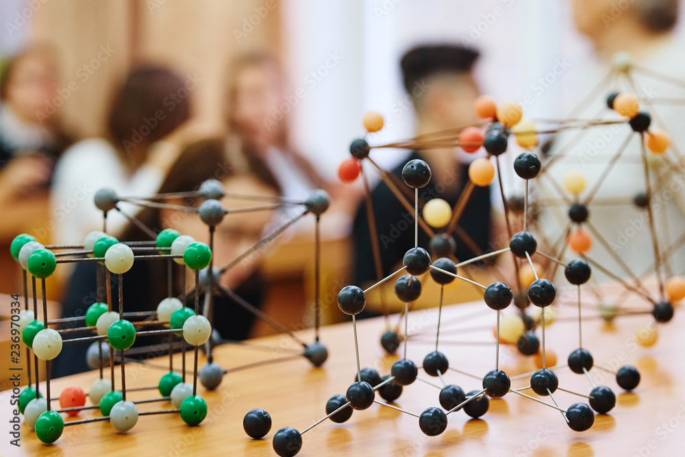 School children in a science class with a molecular model. Background ...