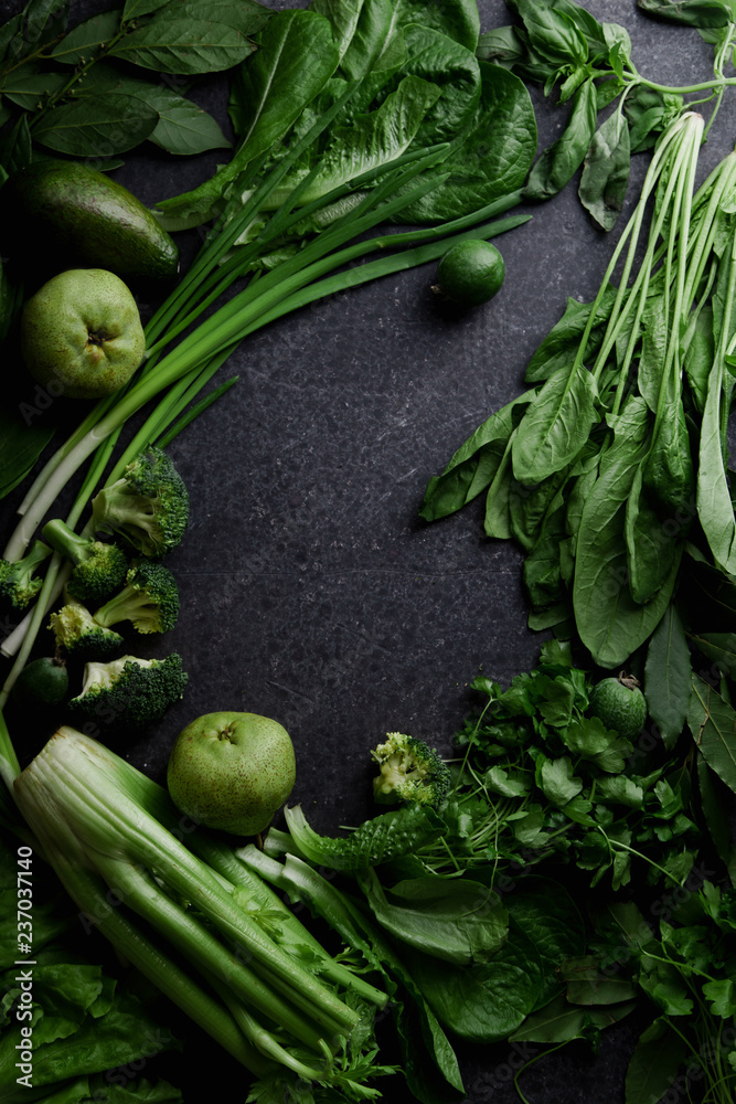 Fresh green food, variety of vegetables, greens and fruits on dark ...