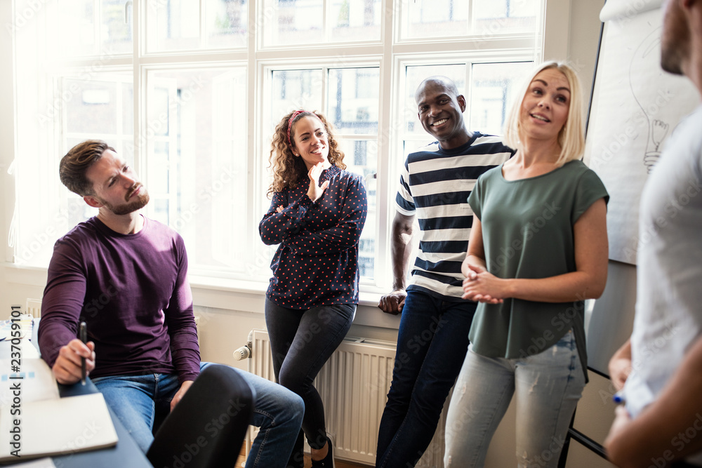 Smiling coworkers talking together after an office presentation Stock ...