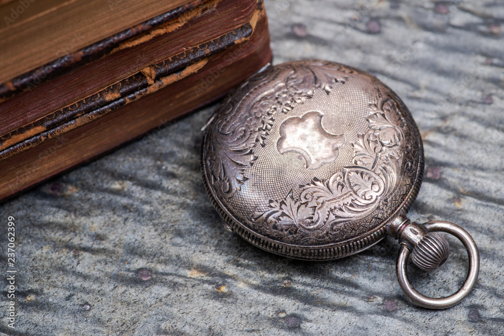Panta rhei concept: antique pocket watch and pile of vintage hard cover ...
