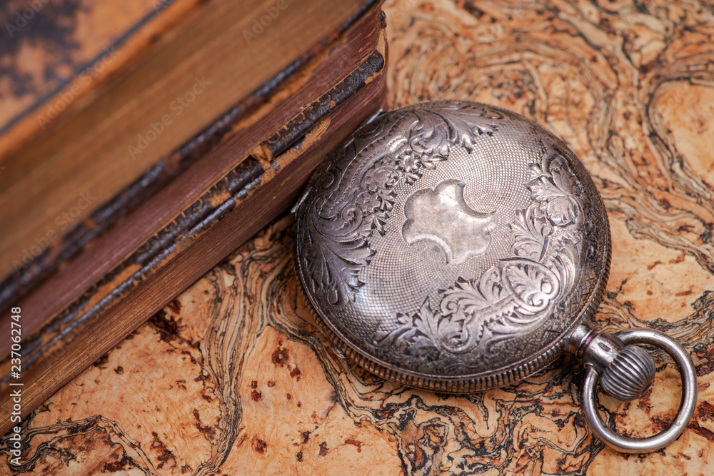 Panta rhei concept: antique pocket watch and pile of vintage hard cover ...