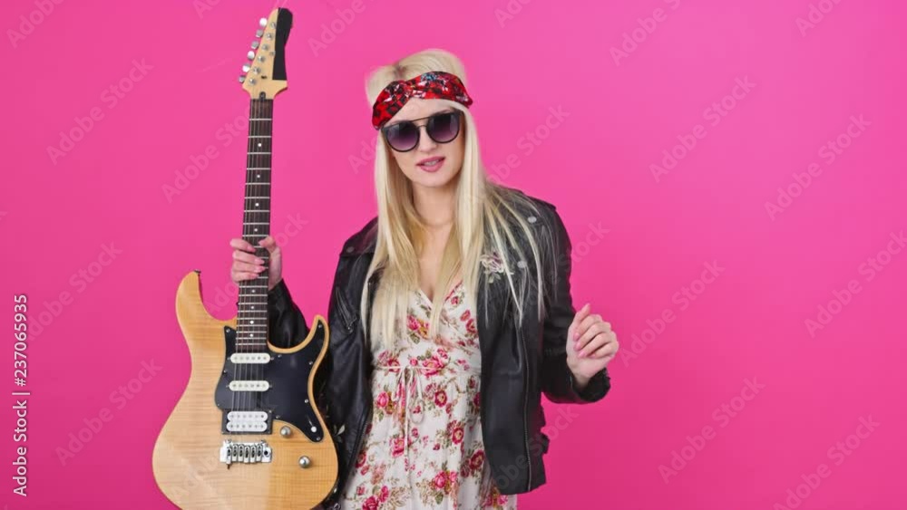 Beautiful, cheerful musician holding a guitar Stock ビデオ | Adobe Stock