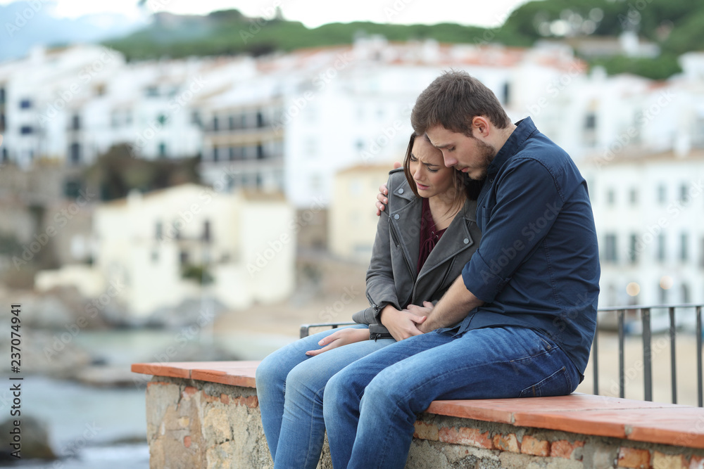 Sad woman and man comforting her on a ledge Stock Photo | Adobe Stock