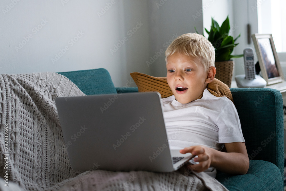 Young boy watching videos on his laptop Stock-Foto | Adobe Stock