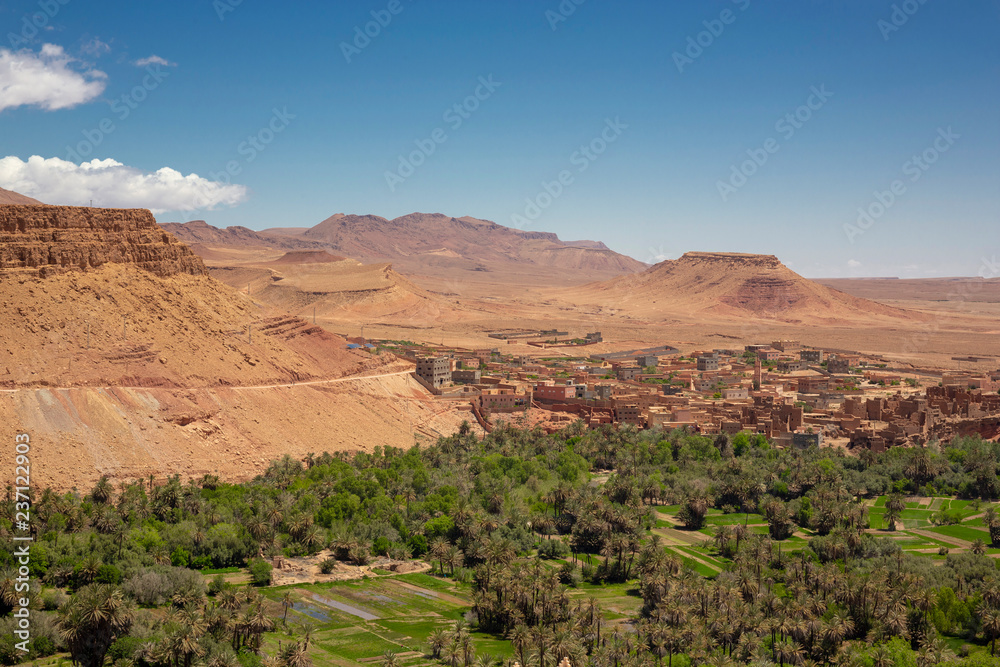 Old town of Tinghir, green palm oasis and rocky Atlas Mountains range ...