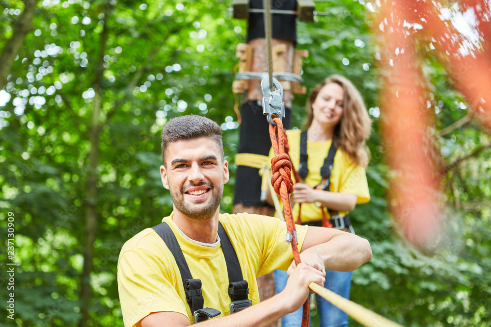Mann im Hochseilgarten mit Seil gesichert Stock Photo | Adobe Stock