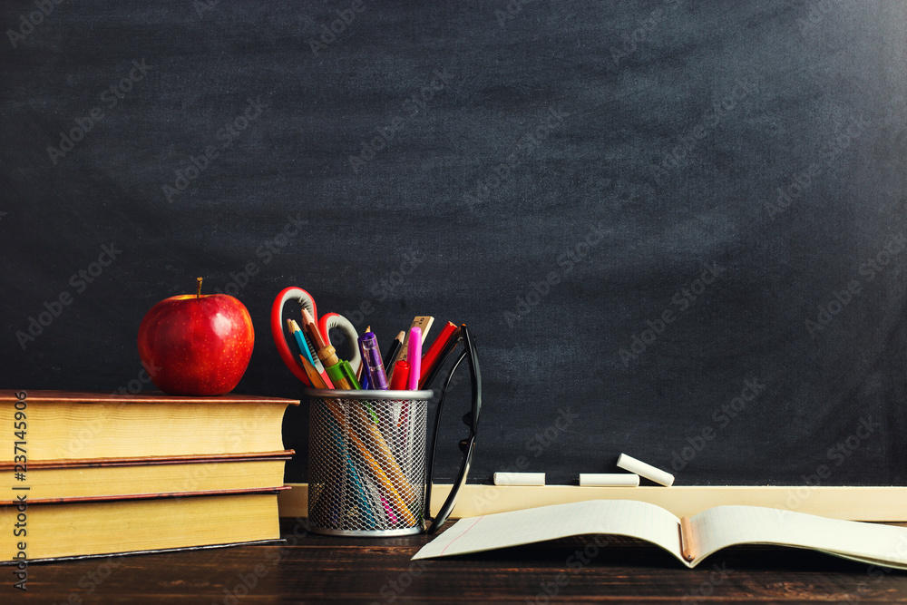Teacher's desk with writing materials, a book and an apple, a blank for ...