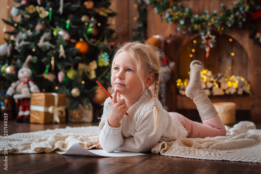 Merry Christmas and Happy Holidays. little child girl writes letter ...