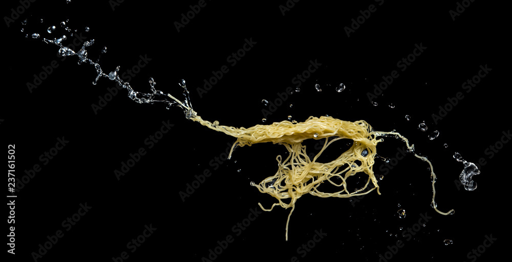 Noodles with soup splash or explosion flying in the air over dark ...