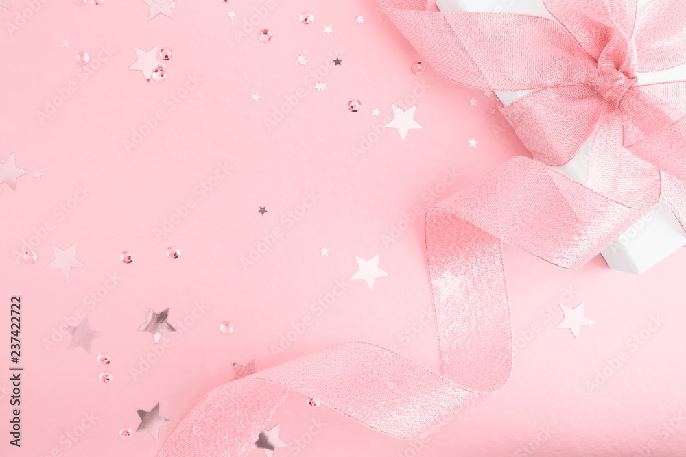 Festive pink background. Gift with satin bow and shining stars on light ...