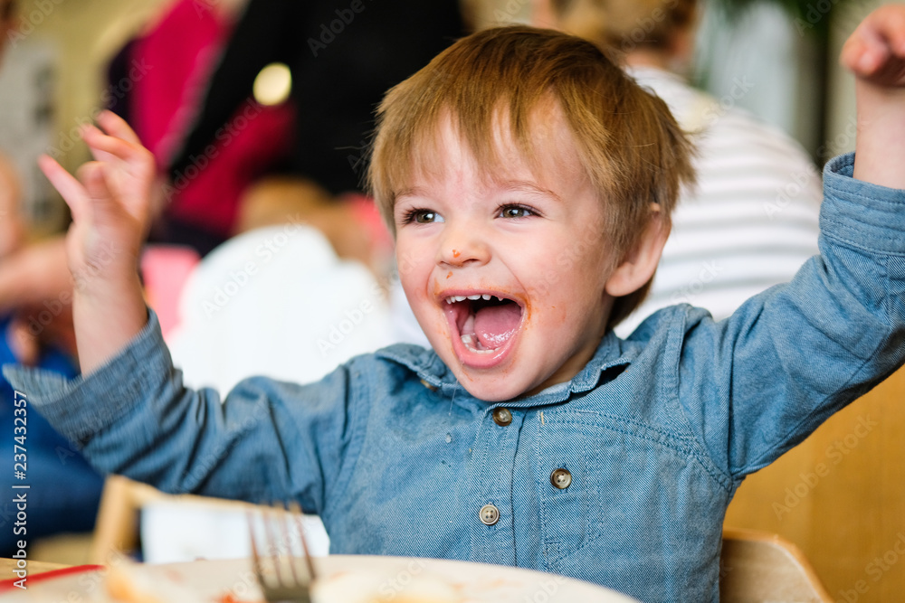 18 month old toddler boy screams with joy after finishing his lunch in ...