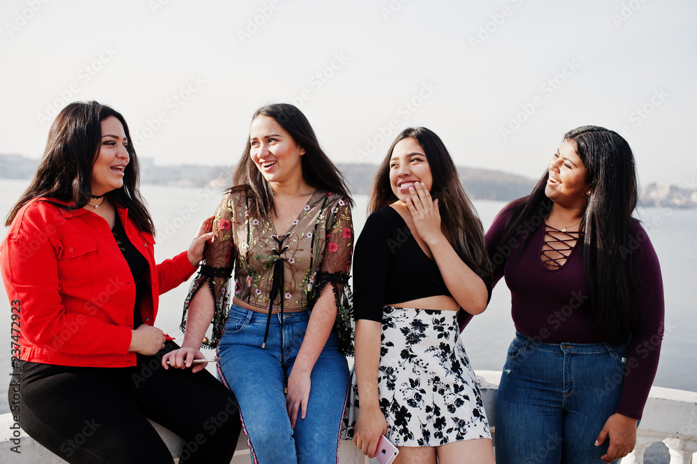 Group of four happy and pretty latino girls from Ecuador posed against ...