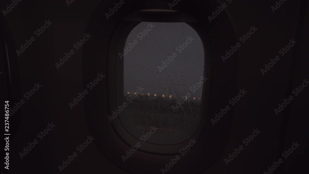 A gloomy view from an airplane porthole. The light is turned off inside ...