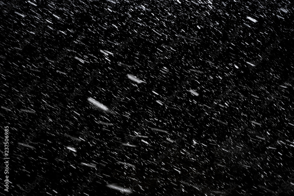 Falling down real snowflakes at the snowstorm weather isolated on black ...