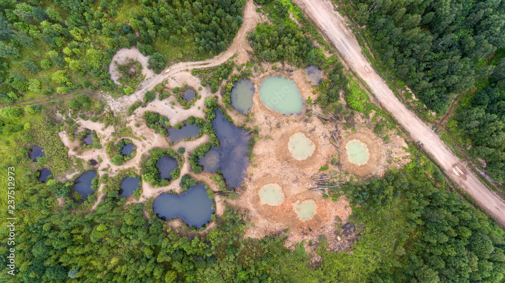 Holes on ground from powerful explosions. Bomb craters in the forest ...
