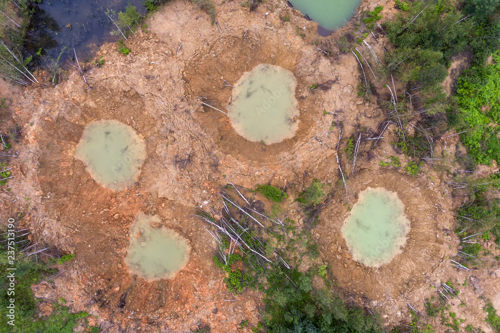 Holes on ground from powerful explosions. Bomb craters in the forest ...