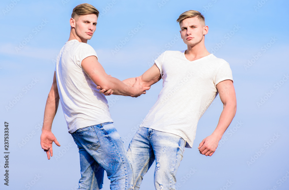 Friendship and support. Men muscular twins brothers in white shirts sky ...
