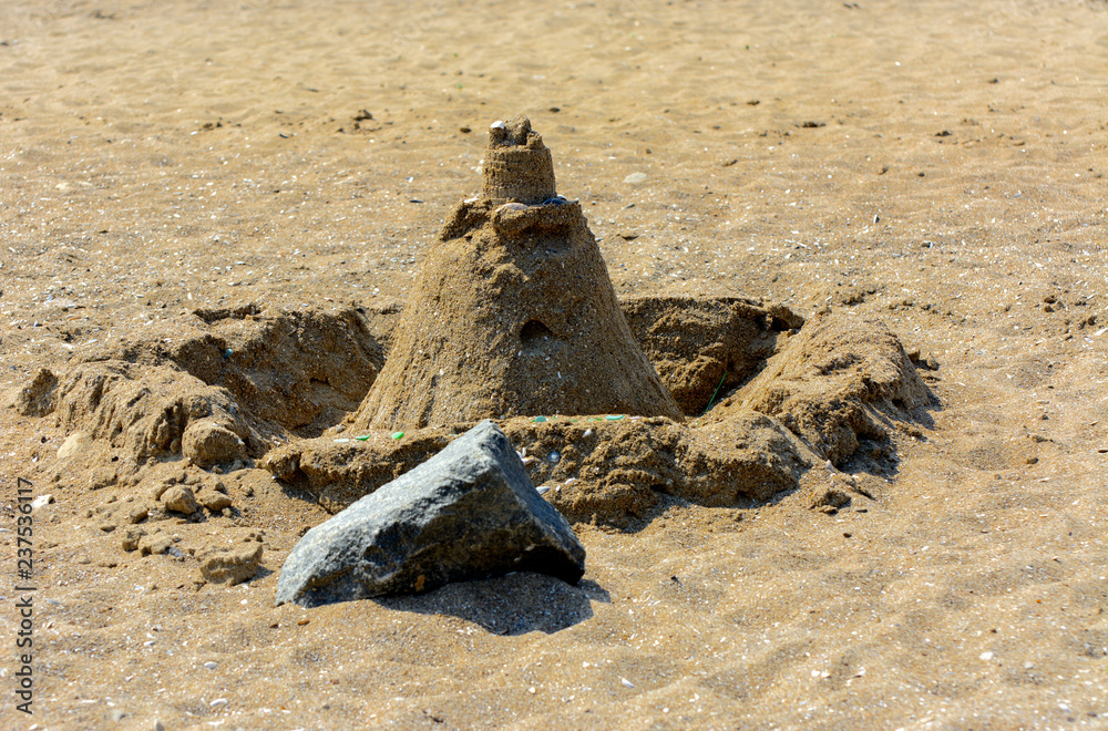 Sandy castle built by children with wet sand on the beach. Castles on ...