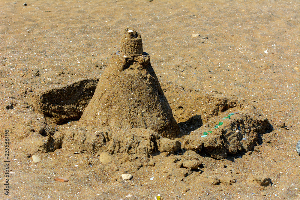 Sandy castle built by children with wet sand on the beach. Castles on ...