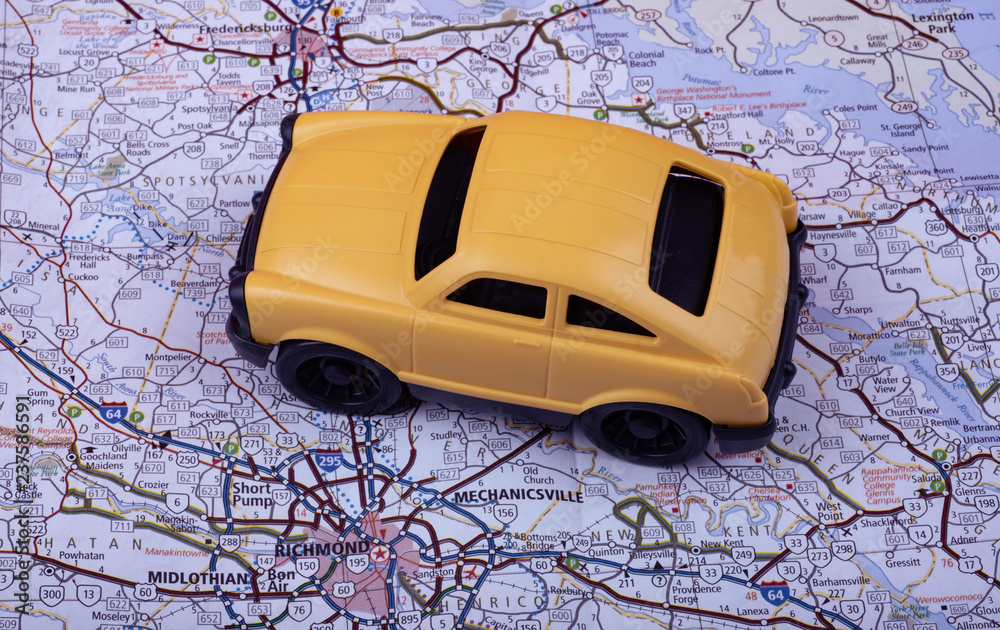 Yellow toy car on map surface. Road trip or rent car concept. Stock ...