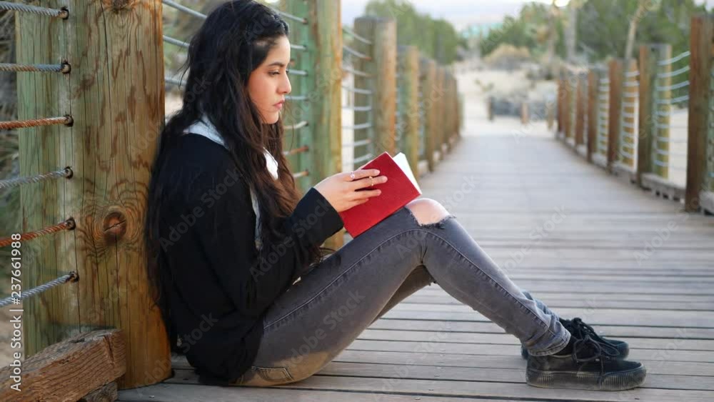 A beautiful girl sitting alone and looking very sad and depressed while ...