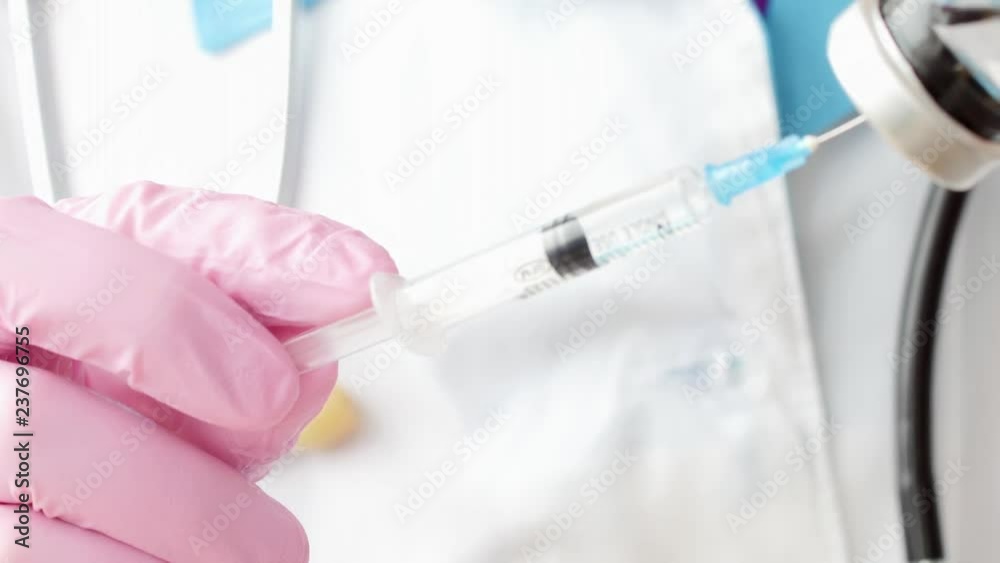 Medical doctor picking up medication into a single use syringe and ...