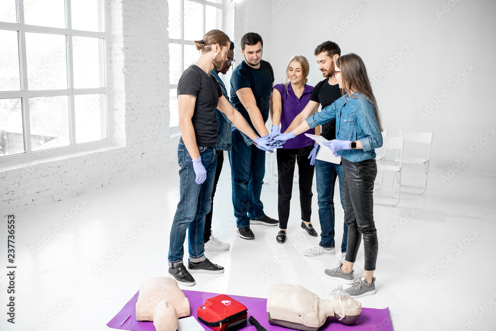 Portrait of a young team of students or coworkers touching hands ...