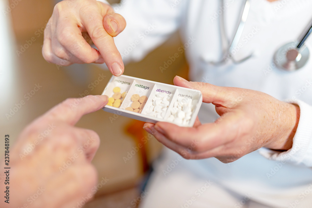 Pflegekraft erklärt Rentnerin die Medikation ihrer Tabletten Stock ...