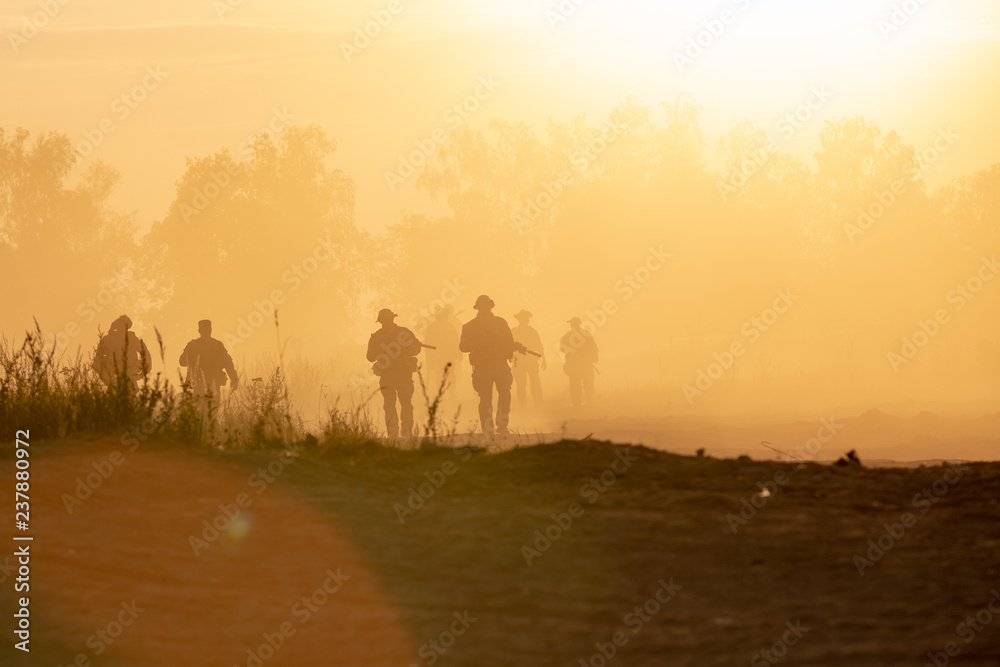 silhouette action soldiers walking hold weapons the background is smoke ...