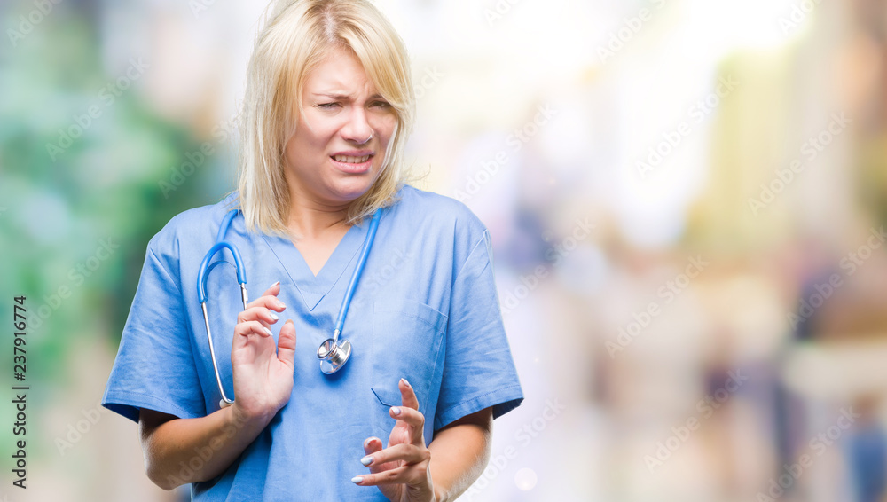 Young beautiful blonde doctor woman wearing medical uniform over ...