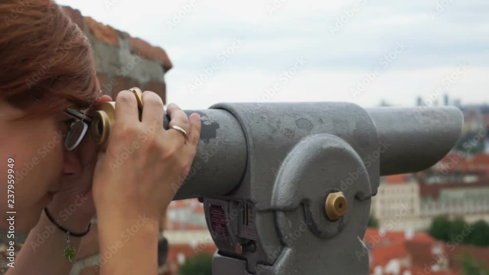 Viewing views through a telescope. The woman is watching the majesto ...