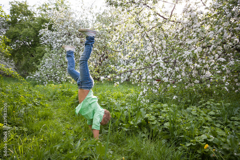 Cute kit boy spinning a wheel in the park. Funny boy standing on his ...