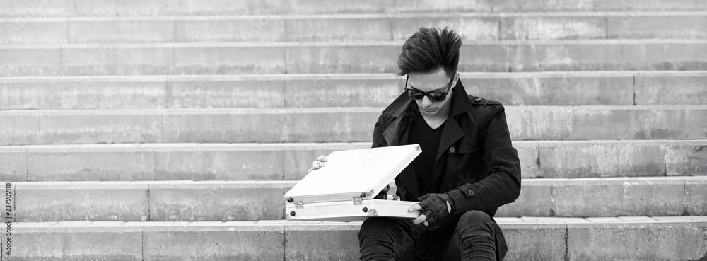 Asian man with a metal suitcase in the city. Asian and silver case ...