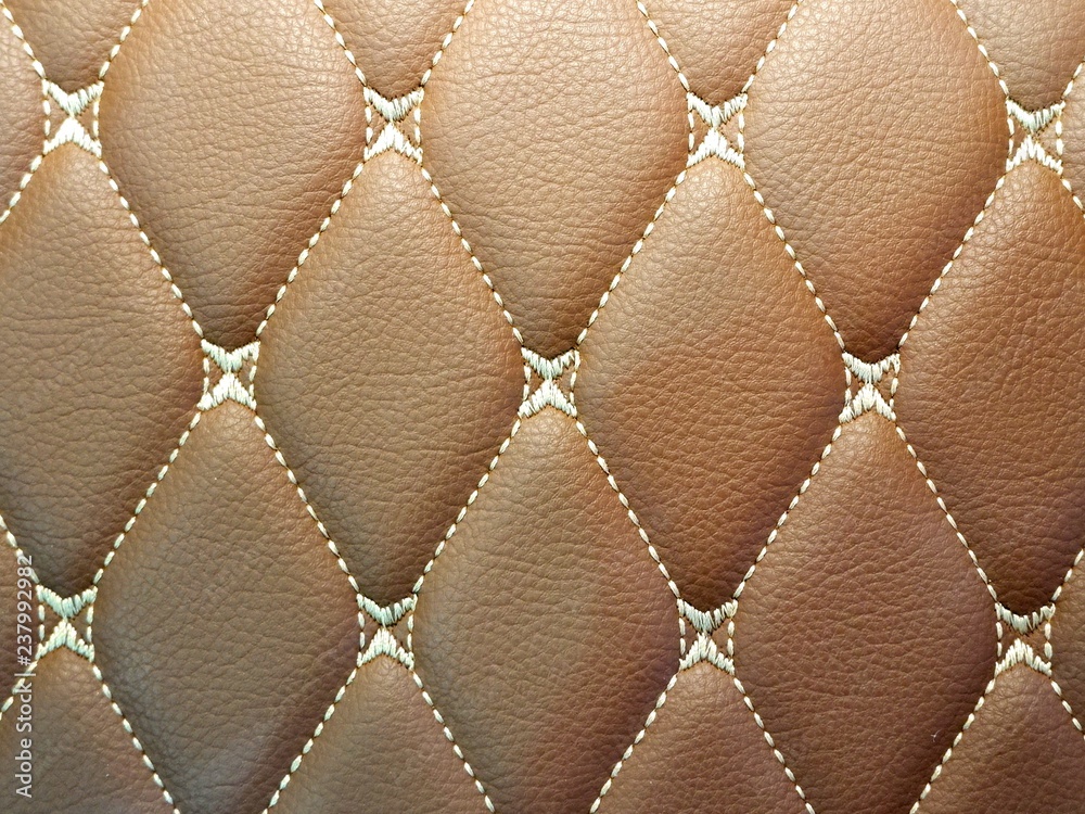 Close up on rhombus pattern and stitch lines of brown leather car seat ...