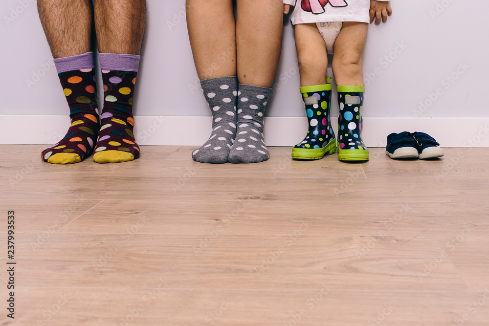 Spotted socks and baby boots with new shoes family feet portrait on an ...
