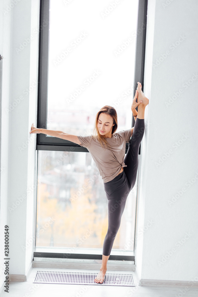 athletic girl concentrated on air split. full length photo.dancer doing ...