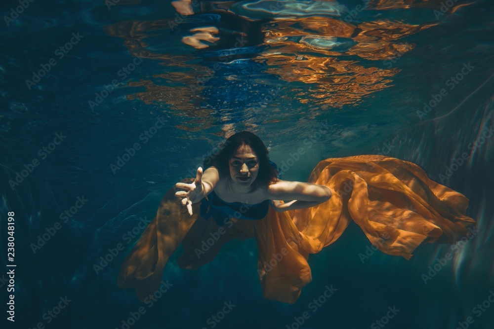 Cute Sporty Female Swims Underwater As A Free Diver In A Blue Evening