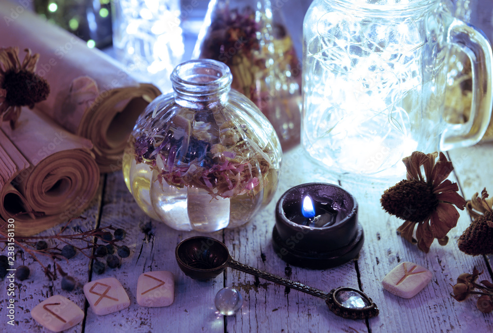 Still life with shining bottles, black candle and runes. Magic gothic ...