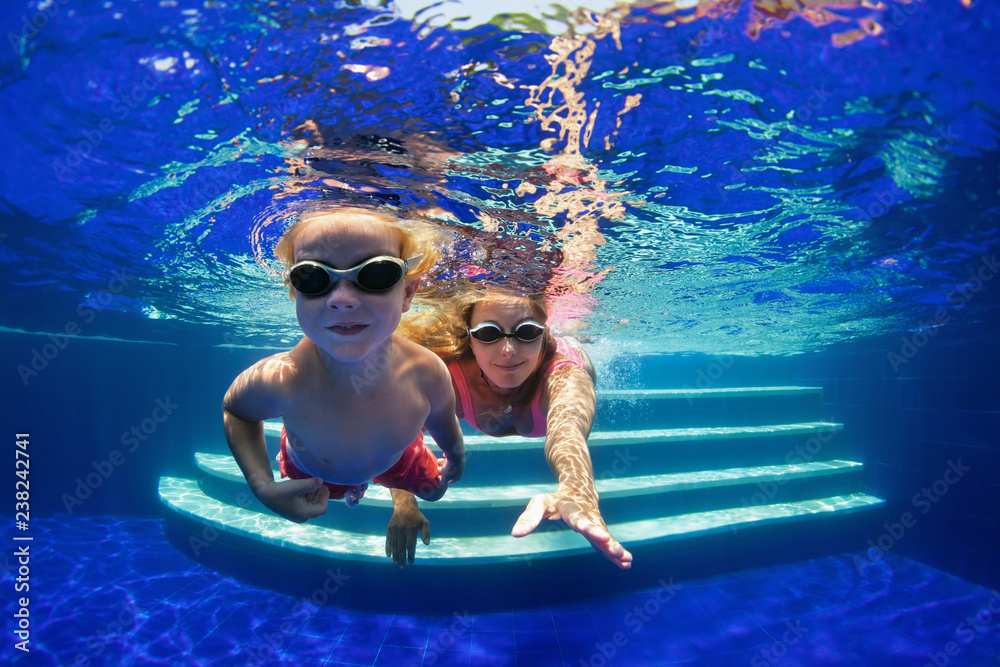 Happy family - mother, baby boy in goggles learn to swim and dive ...