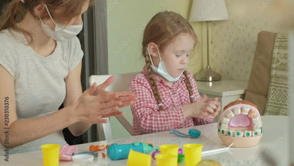 a young woman and a girl mold their teeth from plasticine, insert their ...